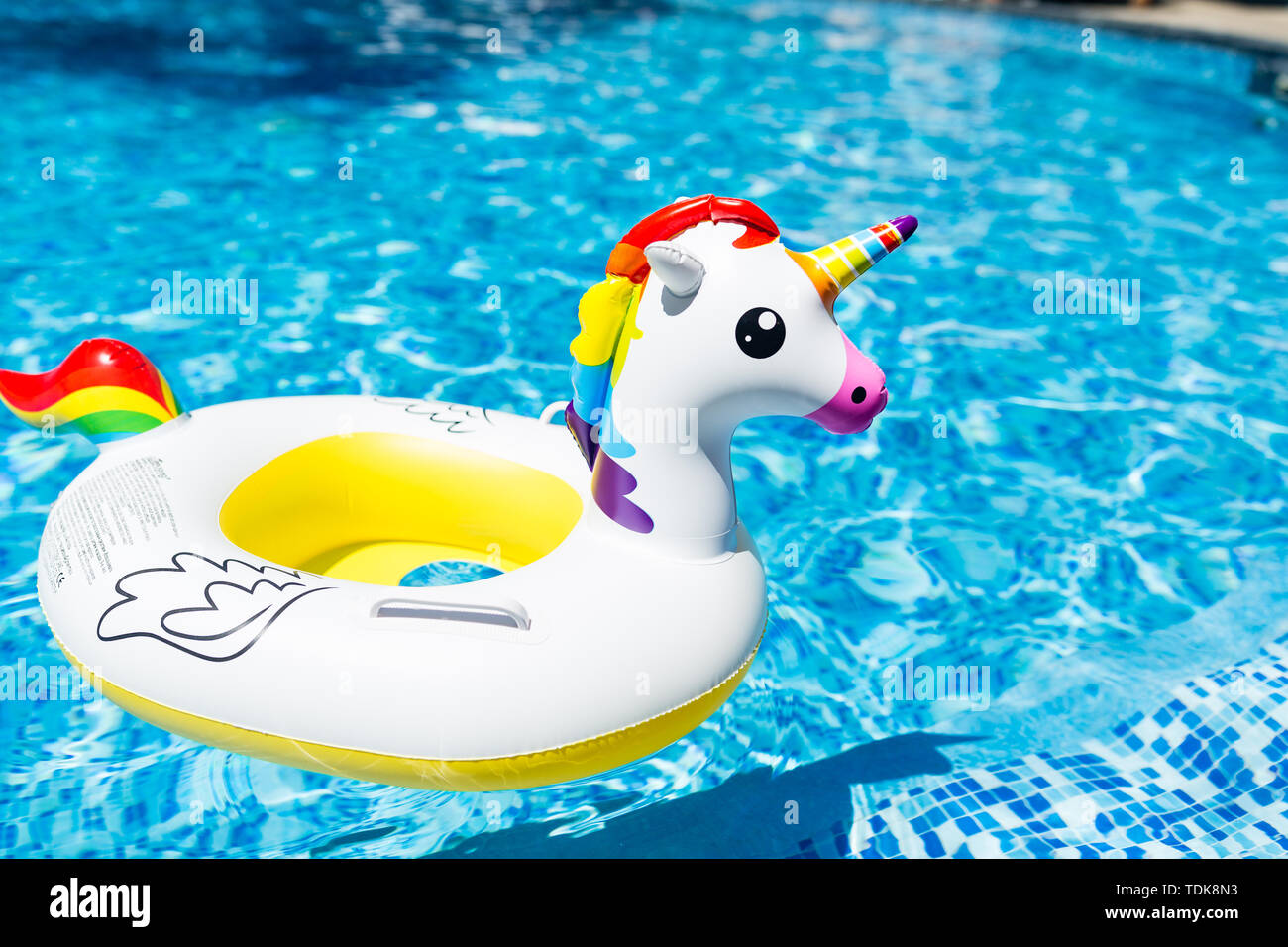 Inflatable colorful white unicorn in the swimming pool. Summer time in ...