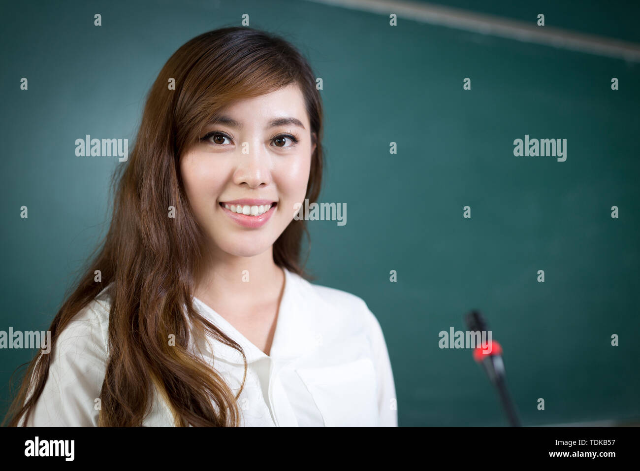 Asian beautiful woman speaking in front of blackboard with micro Stock ...