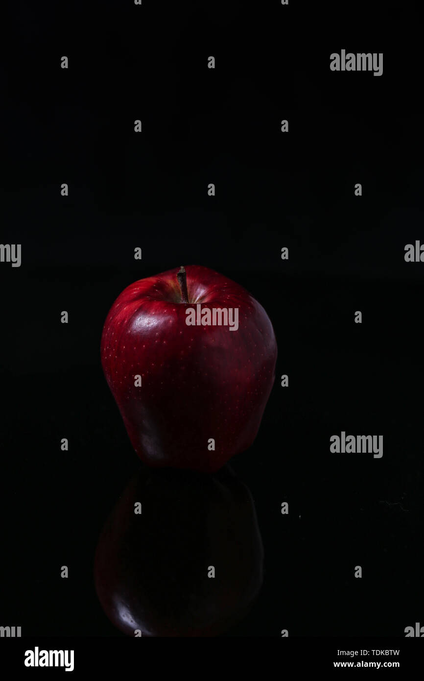 Apple and reflection on black background Stock Photo - Alamy