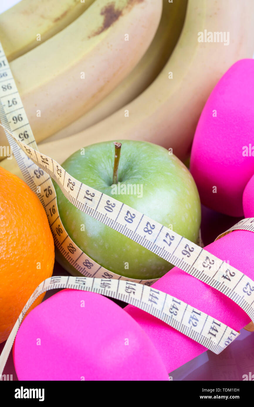 Pink dumbbells and assorted fruits, fitness, healthy eating concept ...