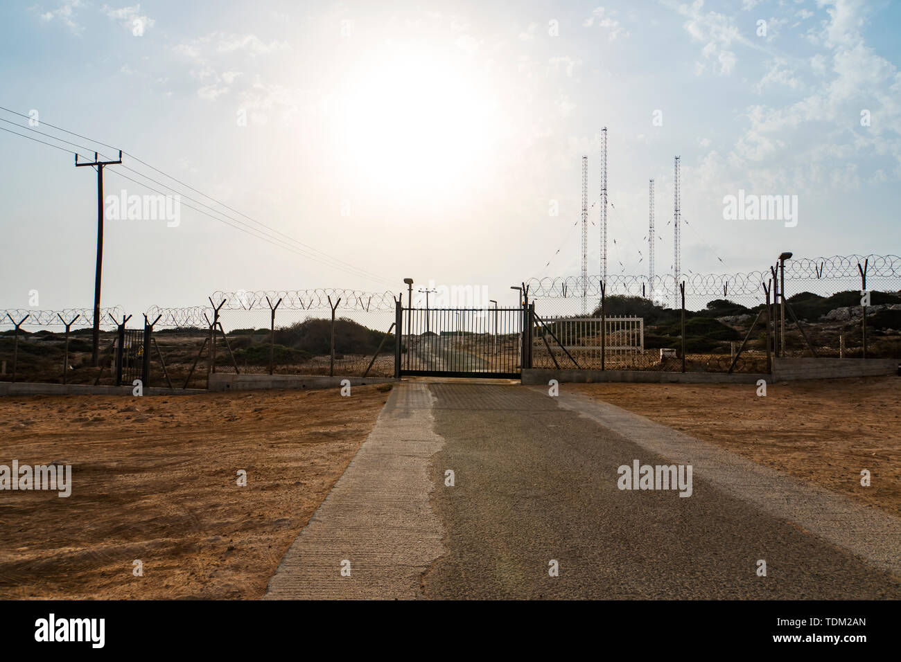 Barbed wire fence block the way. gate to a closed area. Automatic metal ...