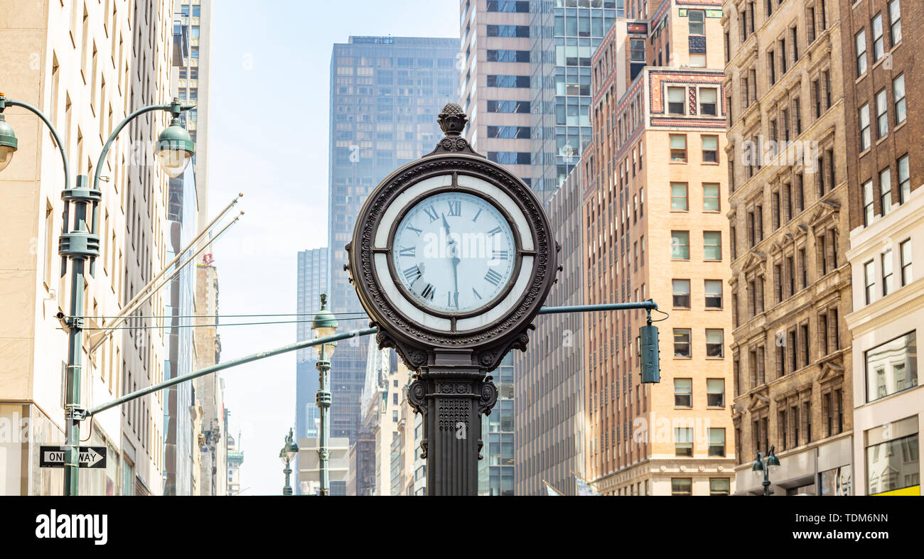 New York, Manhattan 5th ave. Big street cast iron clock on skyscrapers ...