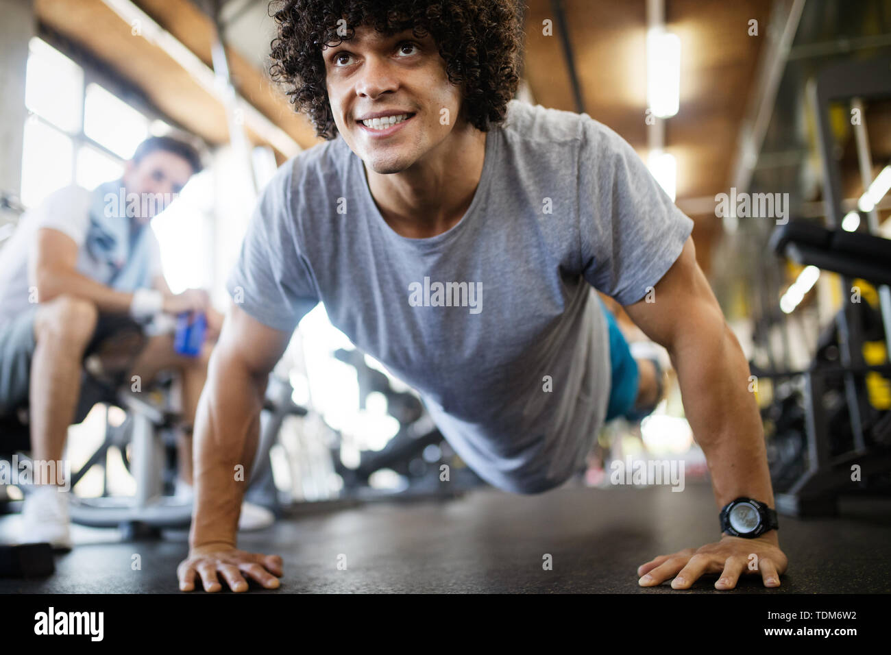 Portrait of a handsome man doing push ups exercise in gym Stock Photo ...