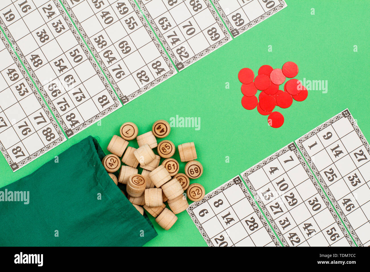 Wooden lotto barrels with cloth bag, game cards and red chips on green ...