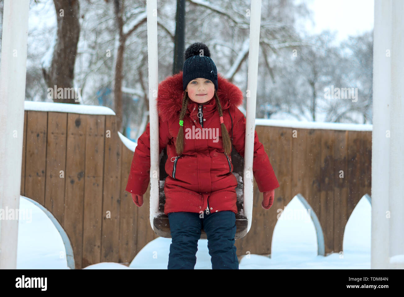 little girl in winter ride on a swing Stock Photo - Alamy