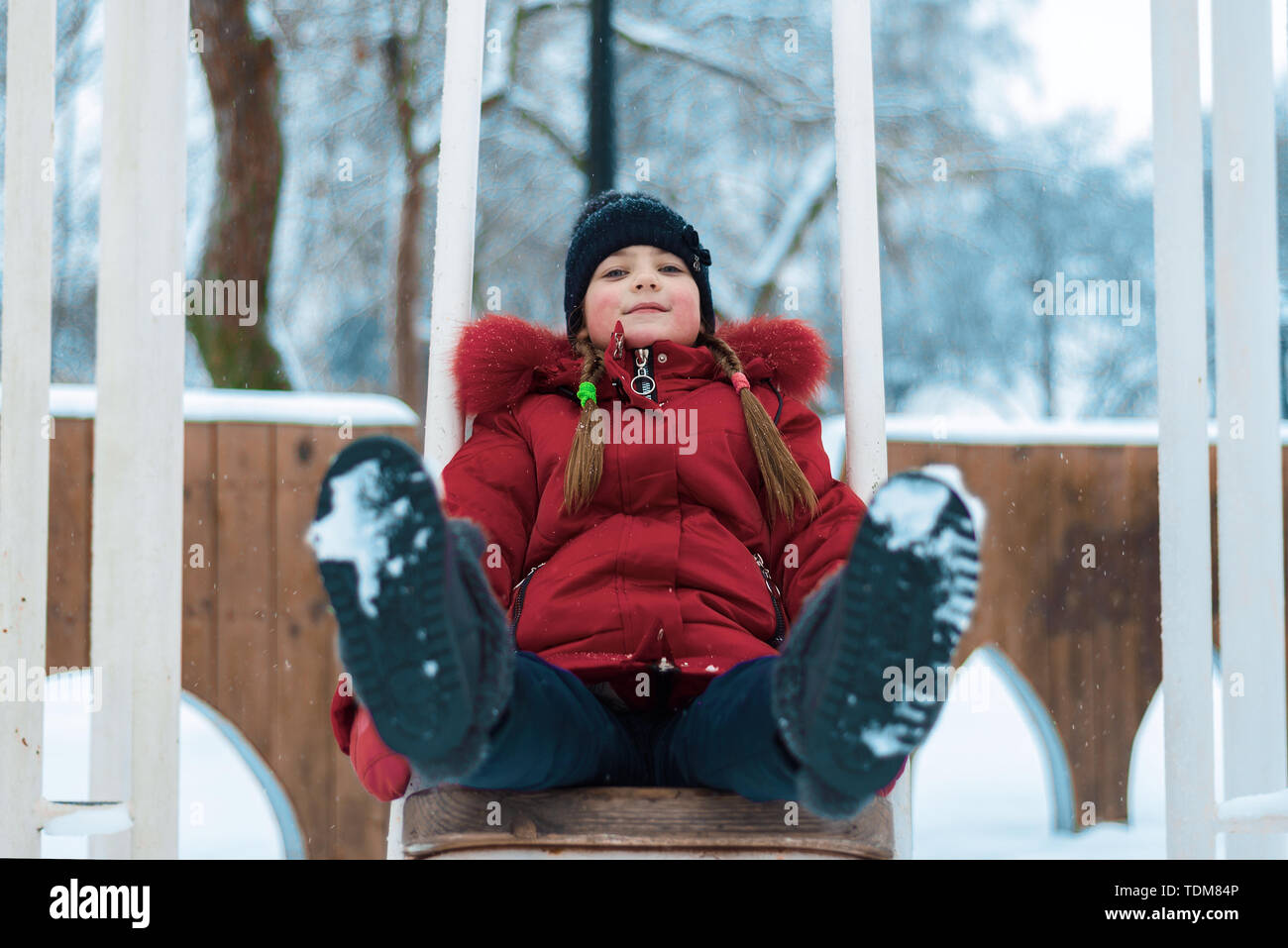 little girl in winter ride on a swing Stock Photo - Alamy