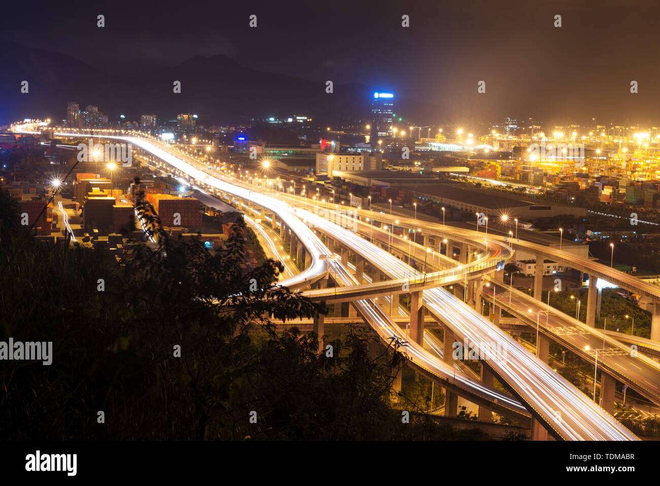 Illuminated and elevated expressway and cityscape at night Stock Photo ...