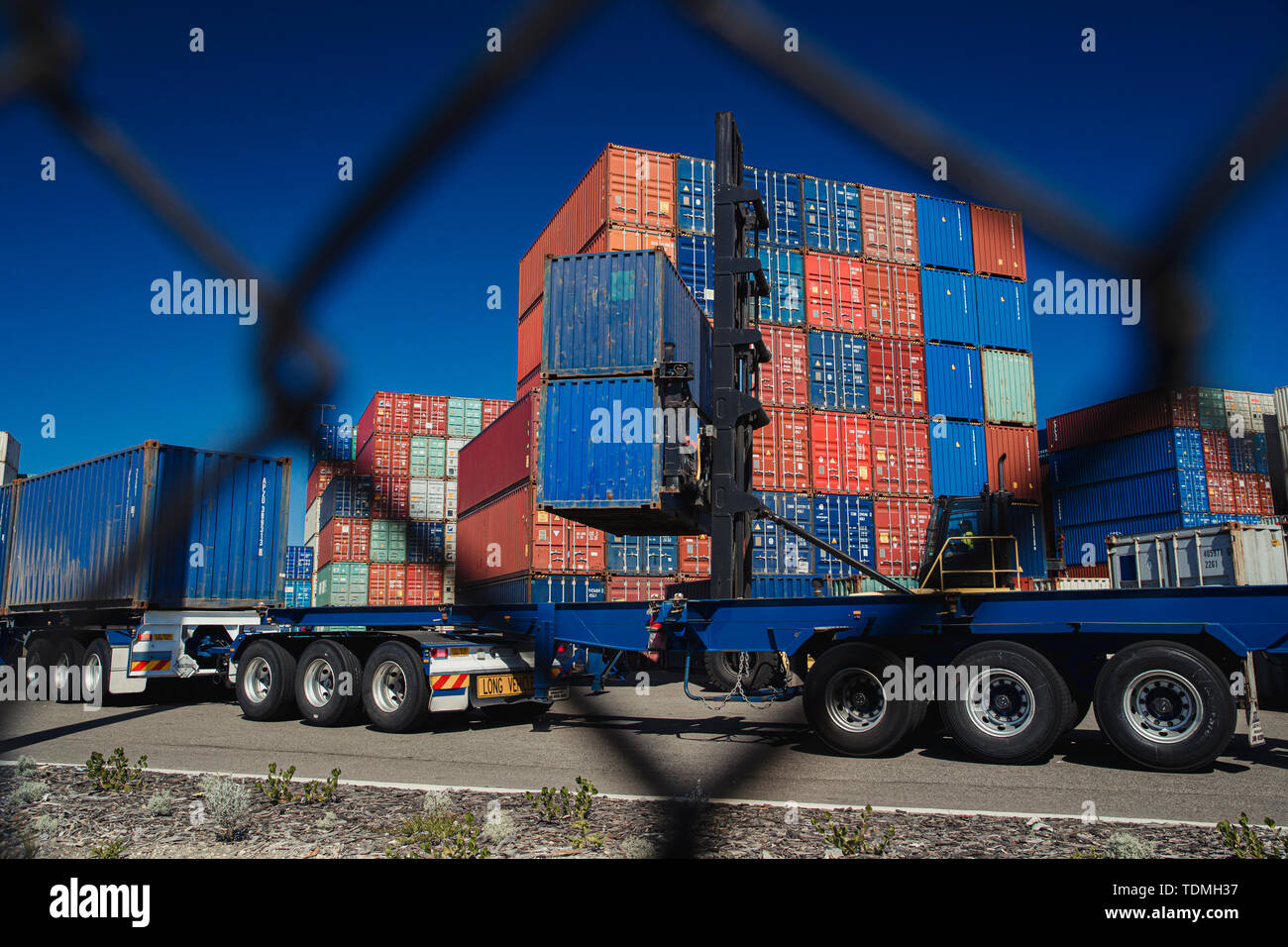Through an object view of stacks of shipping containers at a dock in ...