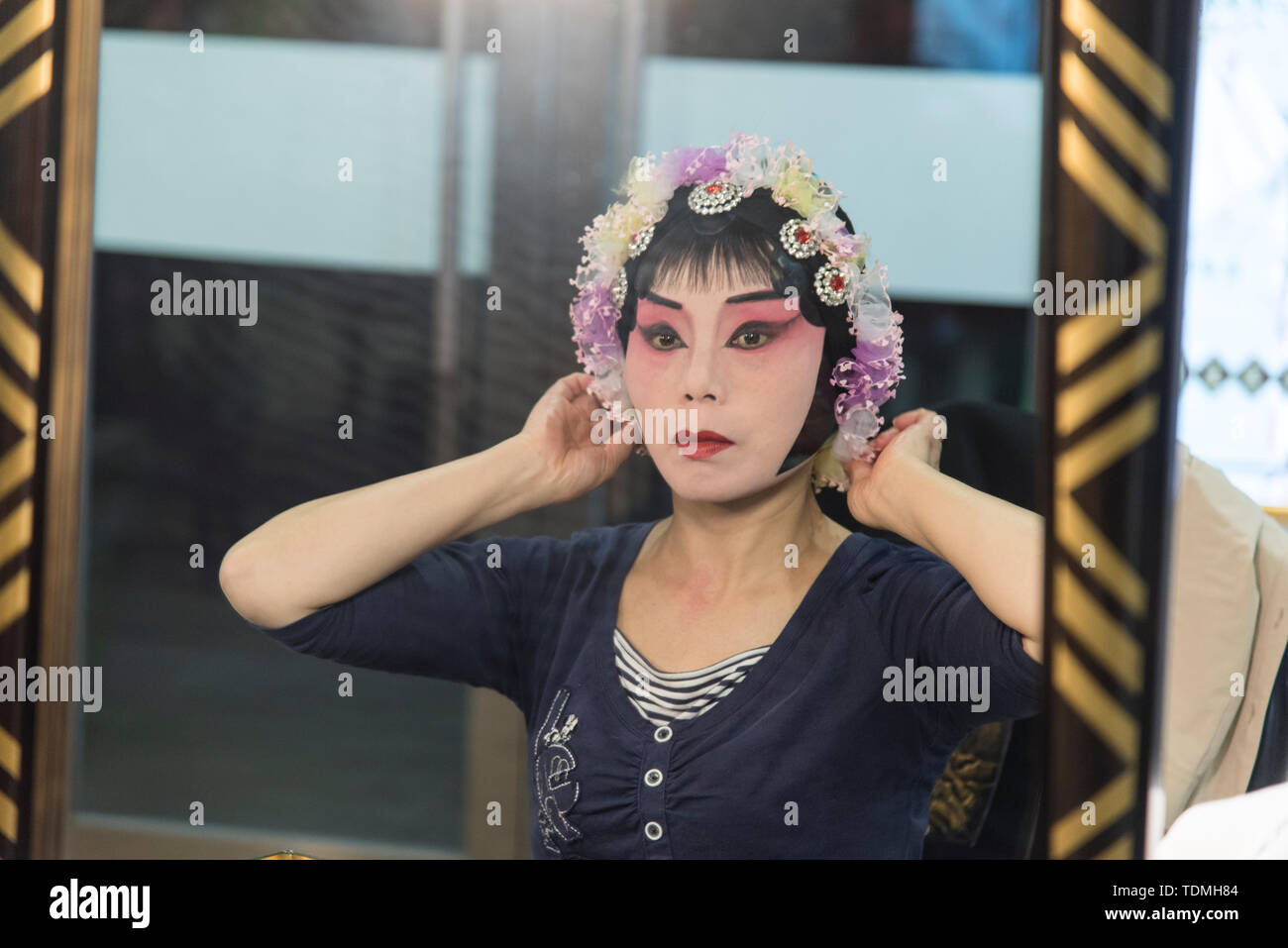 Traditional Chinese actress, applies makeup before a performance in a ...