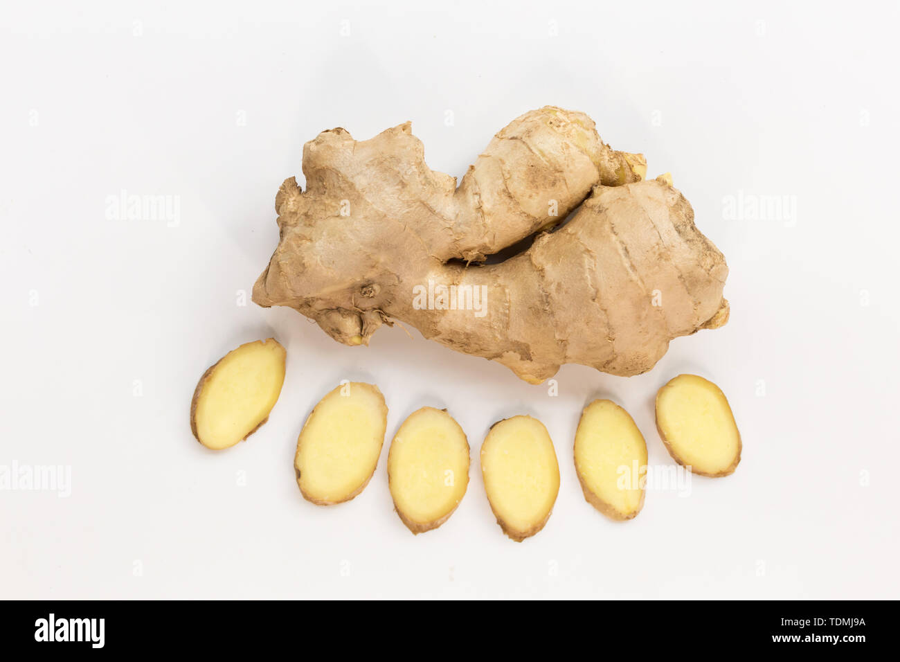 Ginger and cut ginger slices on white background Stock Photo - Alamy