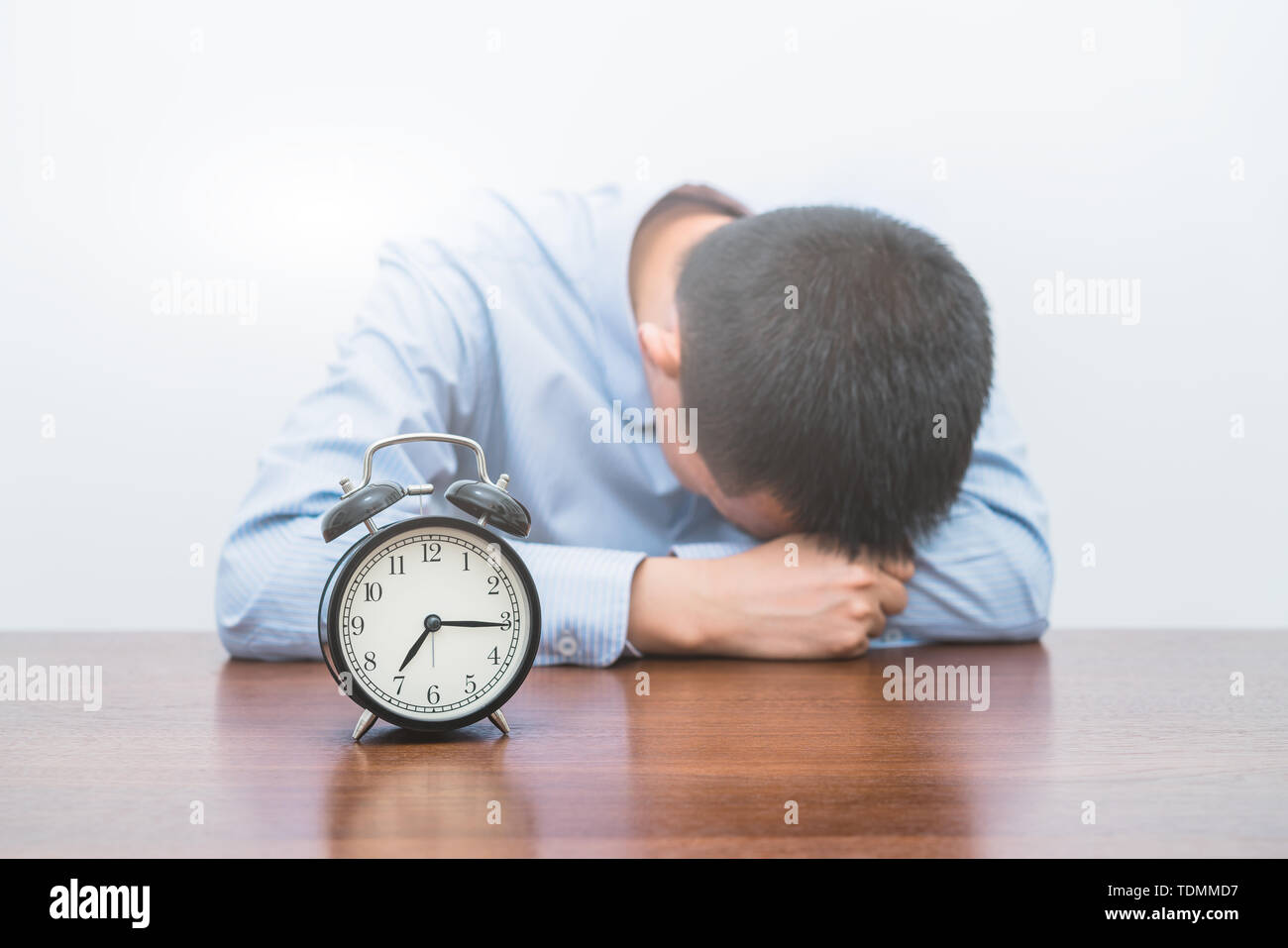 Tired young man lying on the table to rest Stock Photo - Alamy