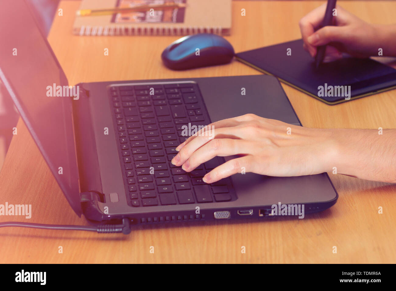 Illustrator using a graphics tablet. Woman's retoucher's hands using ...