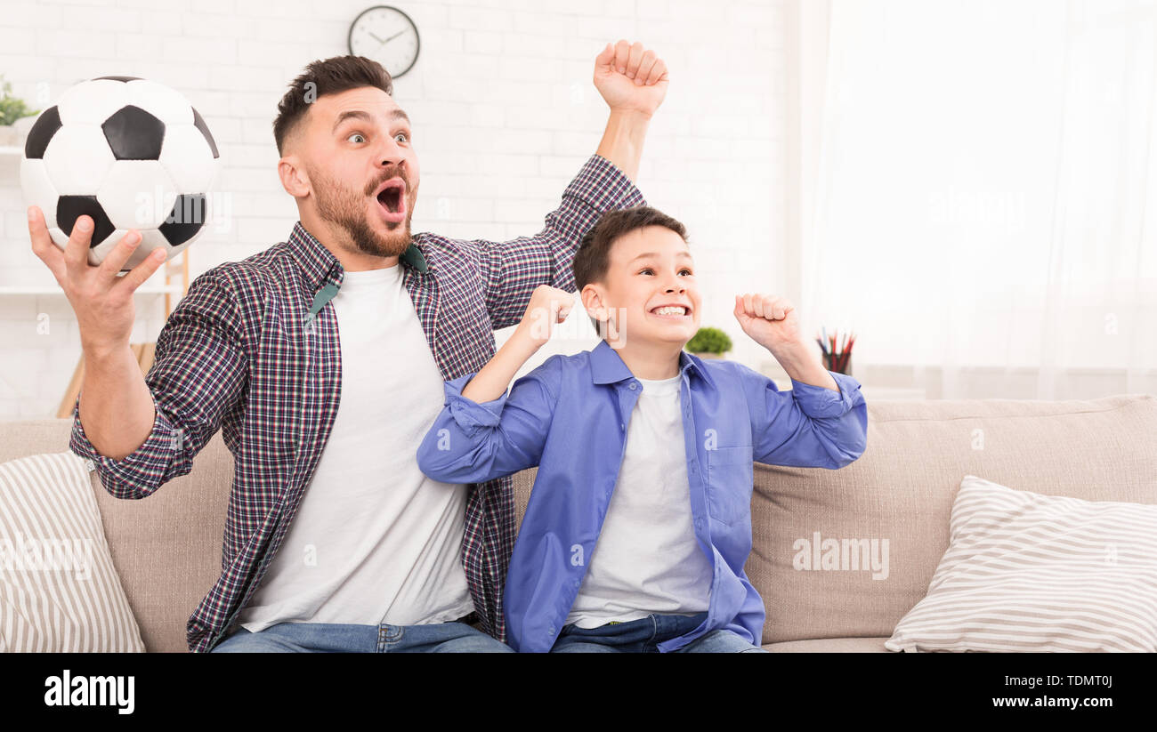 Emotional father and son cheering football with soccer ball Stock Photo ...