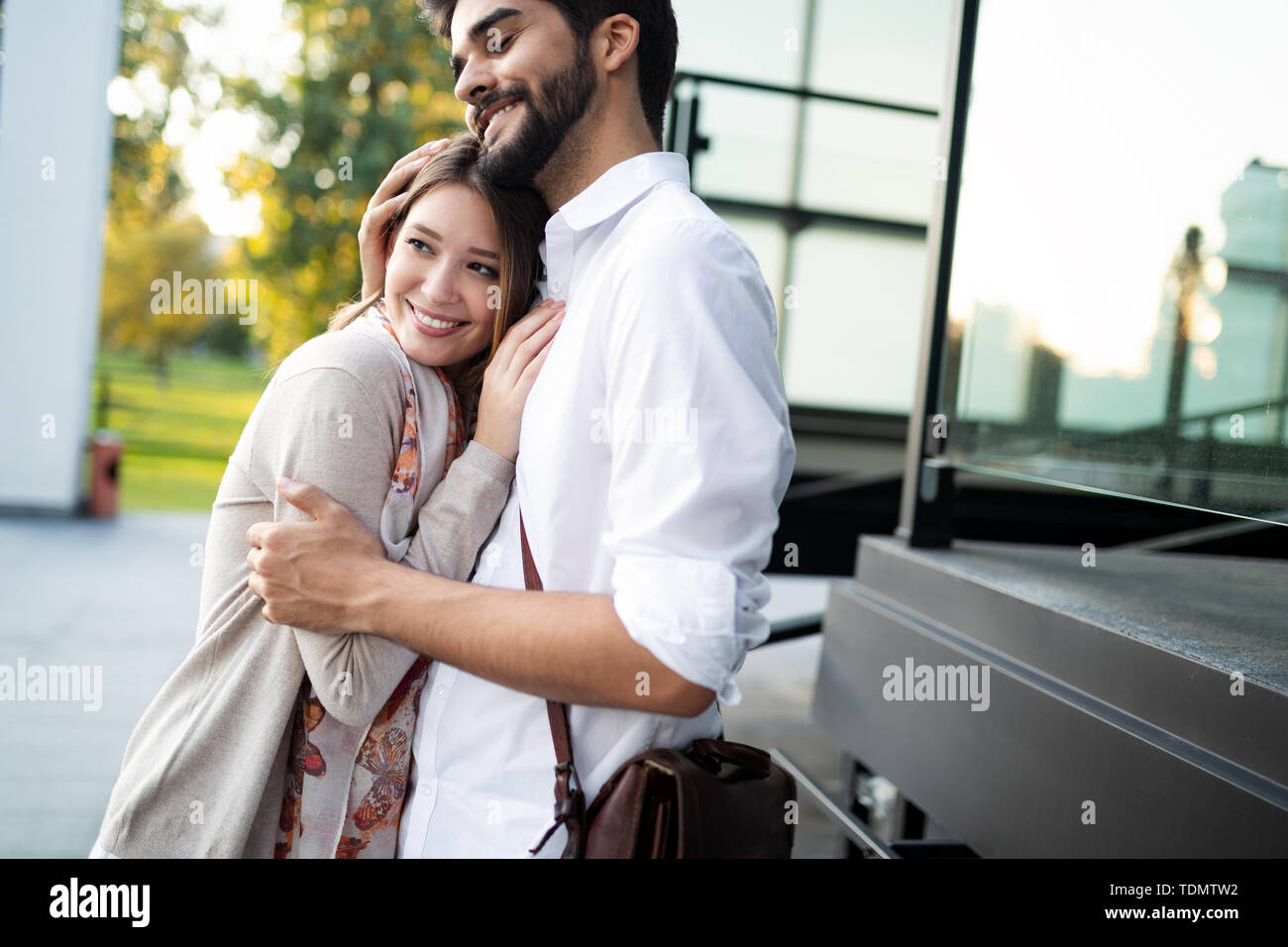 Happy young couple hugging and laughing outdoors Stock Photo - Alamy