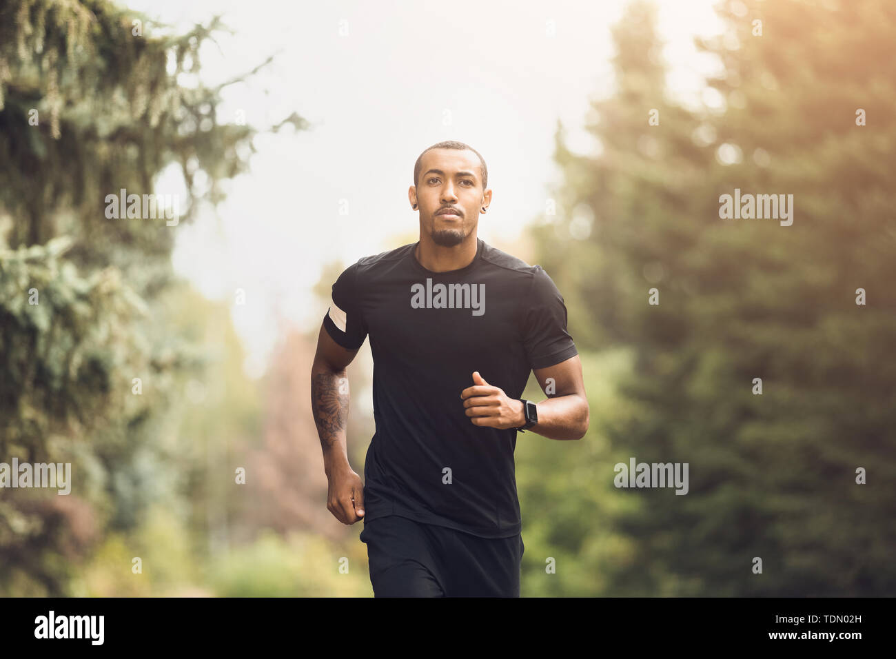 Fit African-American Guy Running In The Park Stock Photo - Alamy
