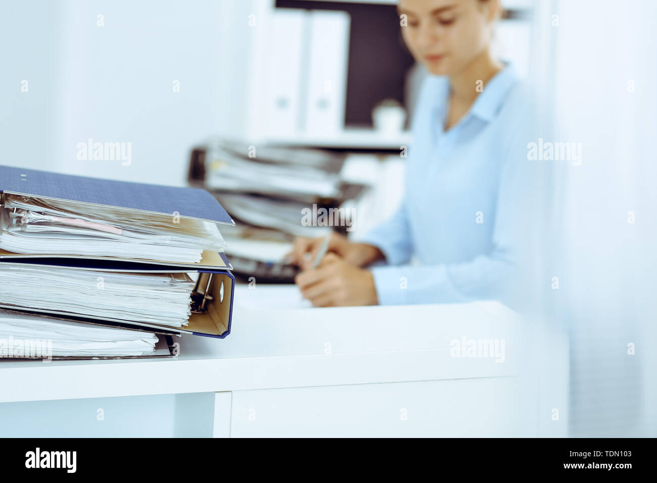 Calculator and binders with papers are waiting to be processed by ...