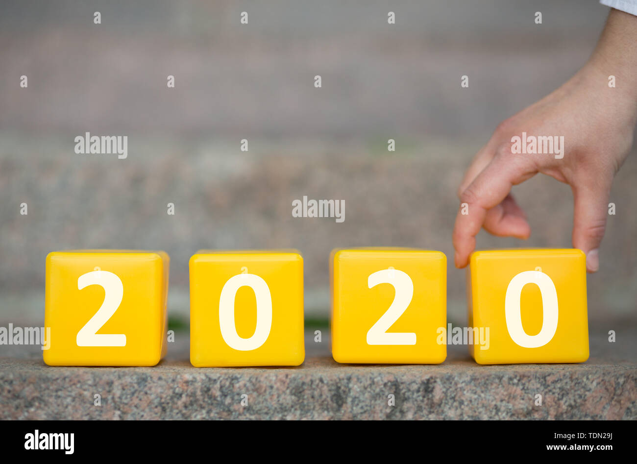 Woman hand laying out cubes with 2020 text on grey asphalt Stock Photo ...