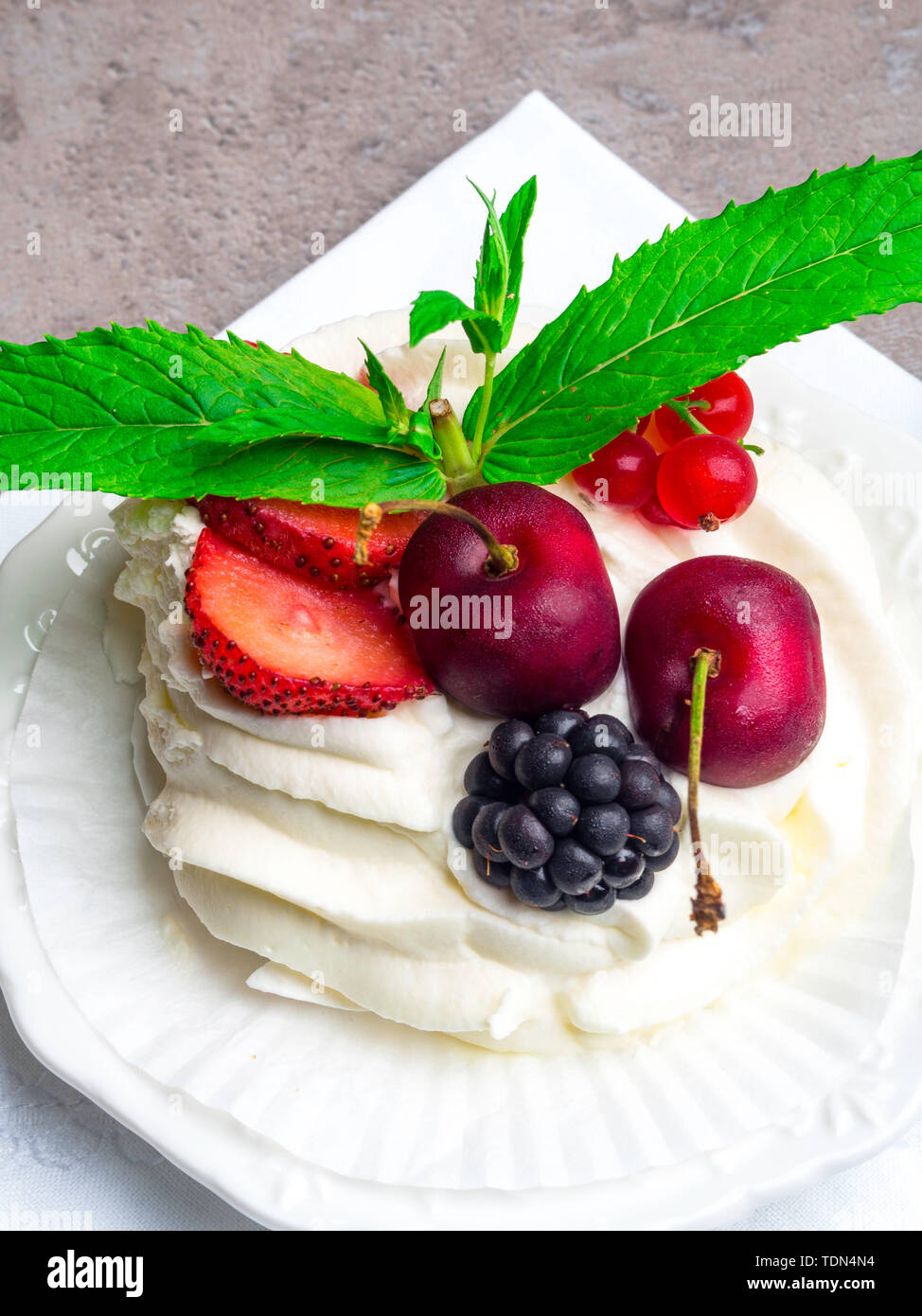 Rustic Pavlova cake with fresh strawberries, cherrys, blackberrys, mint ...