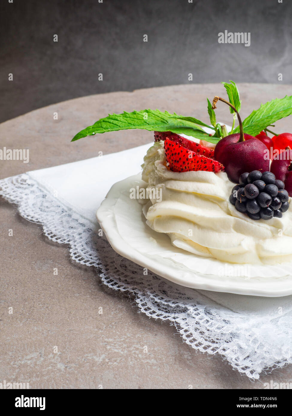 Rustic Pavlova cake with fresh strawberries, cherrys, blackberrys, mint ...