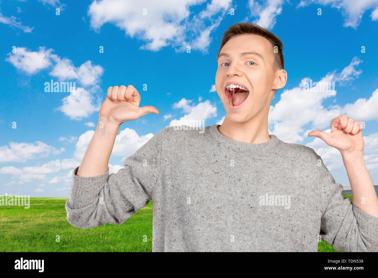 Portrait of smiling young man pointing itself Stock Photo - Alamy