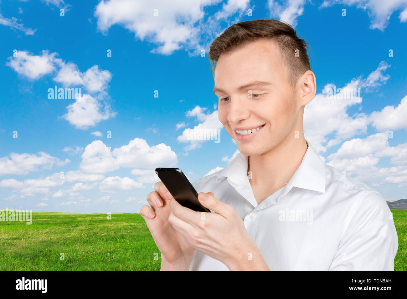 Young man typing text message on his cellphone Stock Photo - Alamy