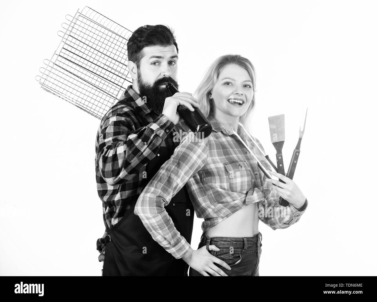 Drinking while cooking. Happy couple using cooking grid for barbecue ...