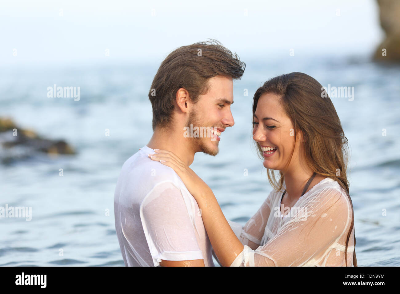 Happy couple laughing bathing on the beach on summer vacation Stock ...