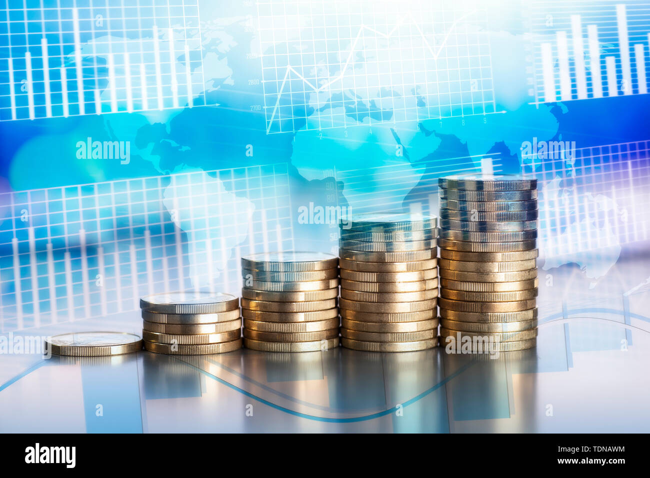 Rising stacks of coins and graphs and charts in the background Stock ...
