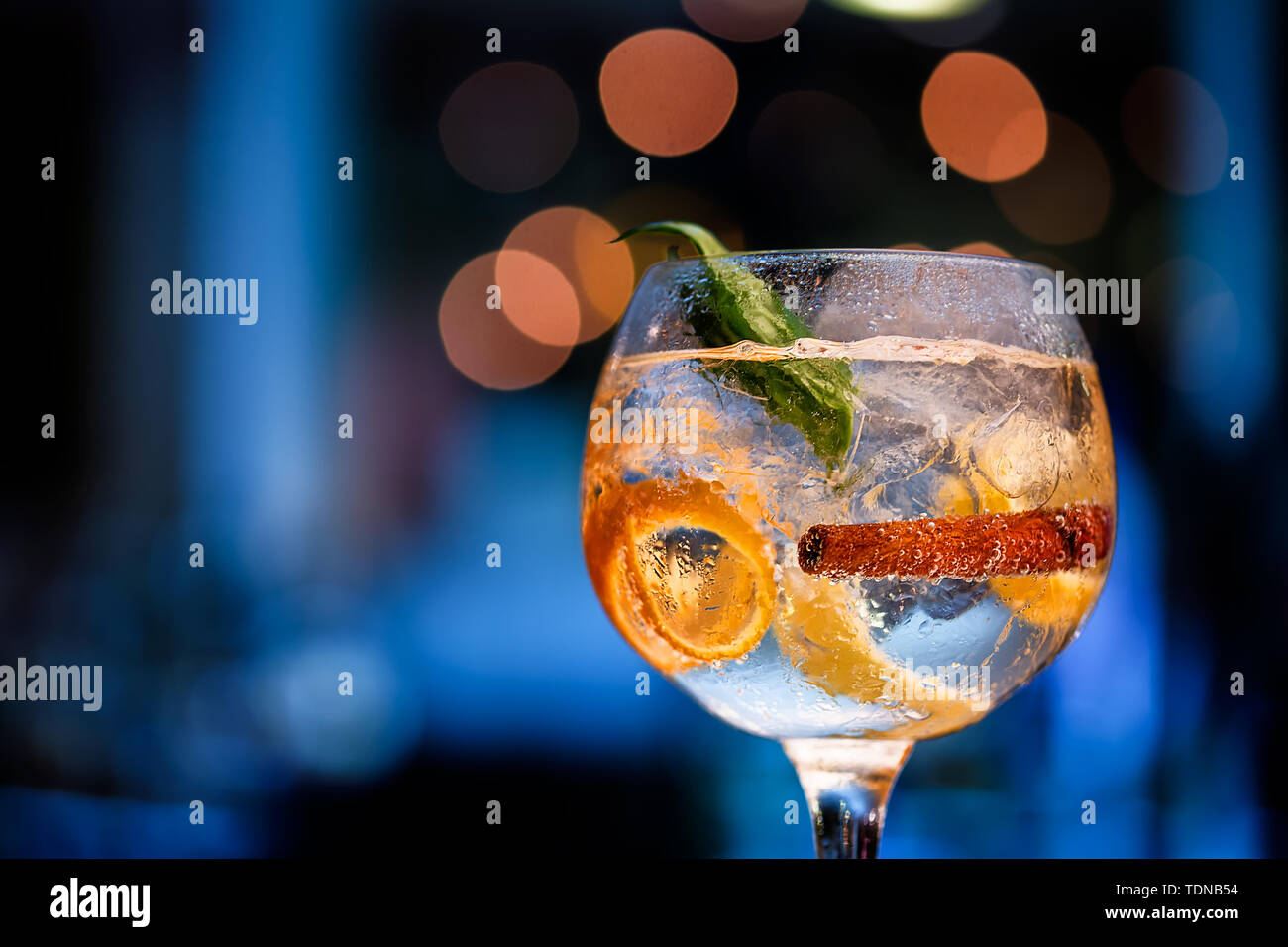 Beautiful glass of gin on bar counter with blurred background in shades ...