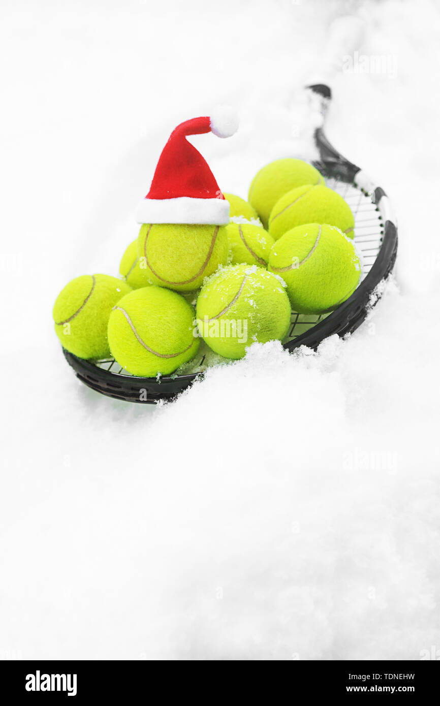 Tennis winter concept with tennis balls and racket on white snow ...