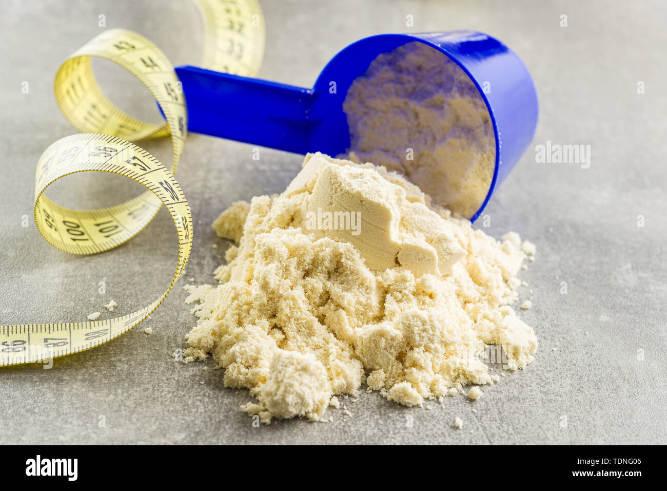 Whey protein powder in scoop and measuring tape Stock Photo - Alamy