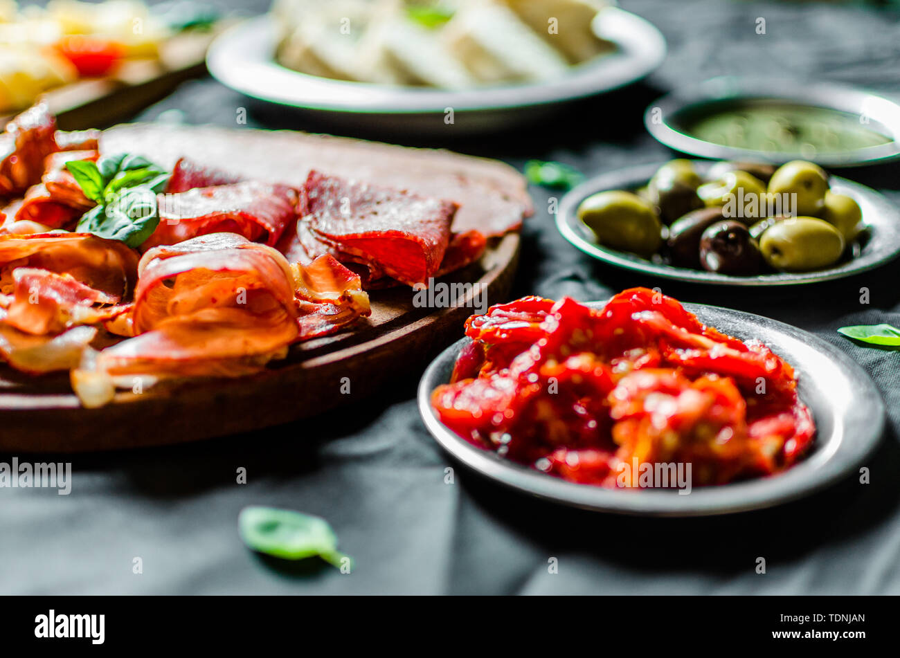 Italian cold meat antipasti delicatessen platter against black ...
