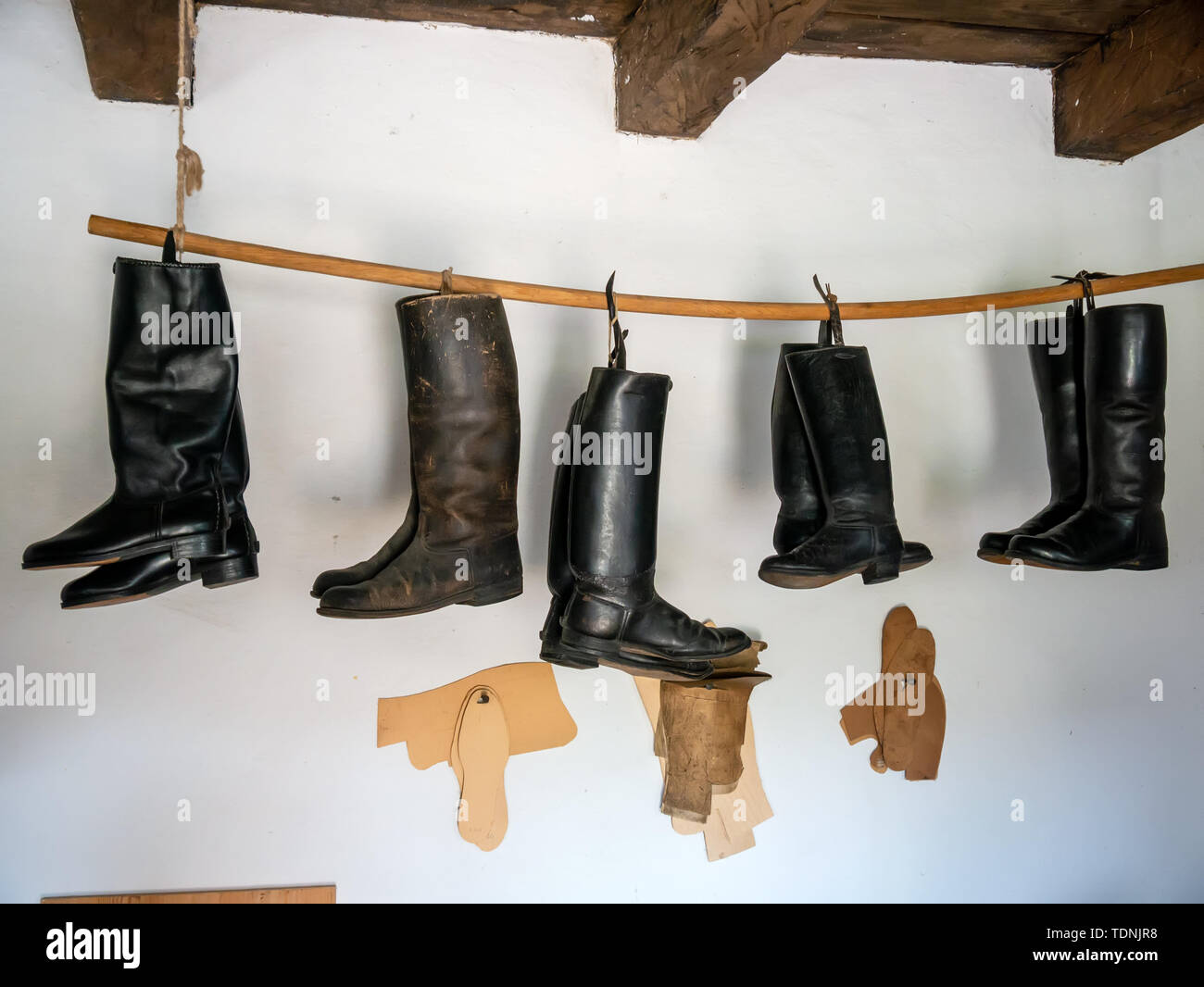 View on traditional leather boots hanged on a rope Stock Photo - Alamy