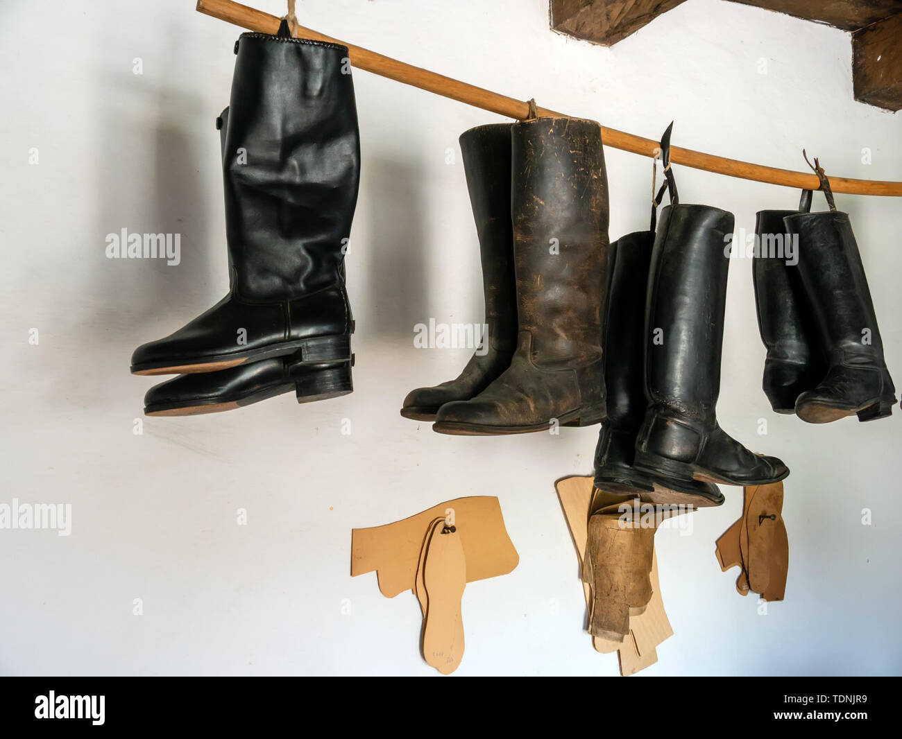View on traditional leather boots hanged on a rope Stock Photo - Alamy