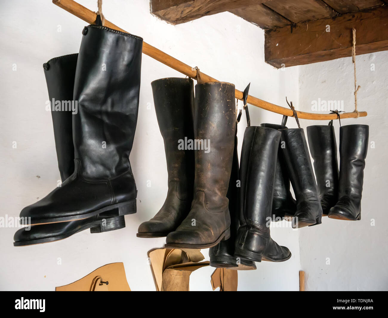 View on traditional leather boots hanged on a rope Stock Photo - Alamy