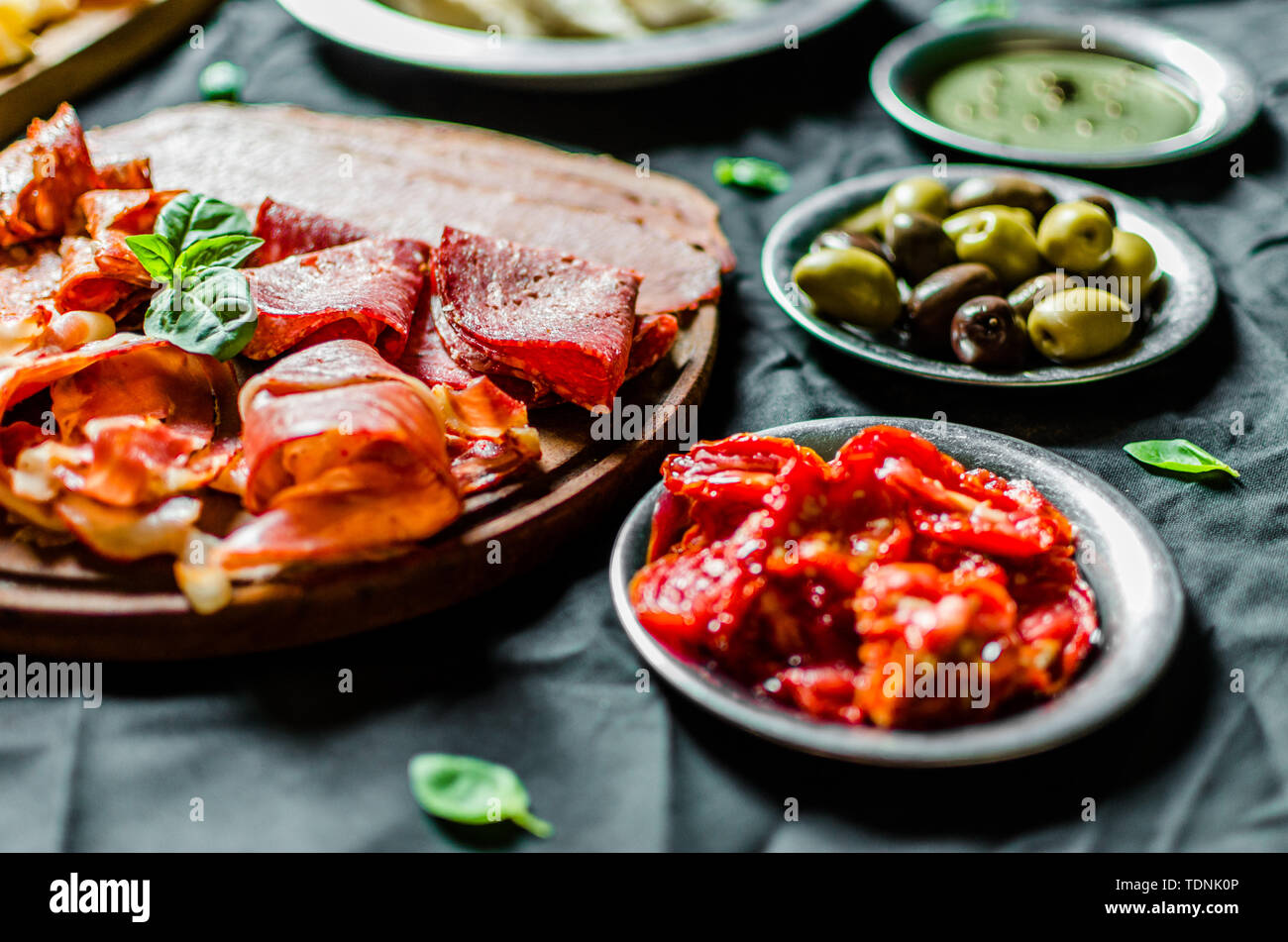 Italian cold meat antipasti delicatessen platter against black ...