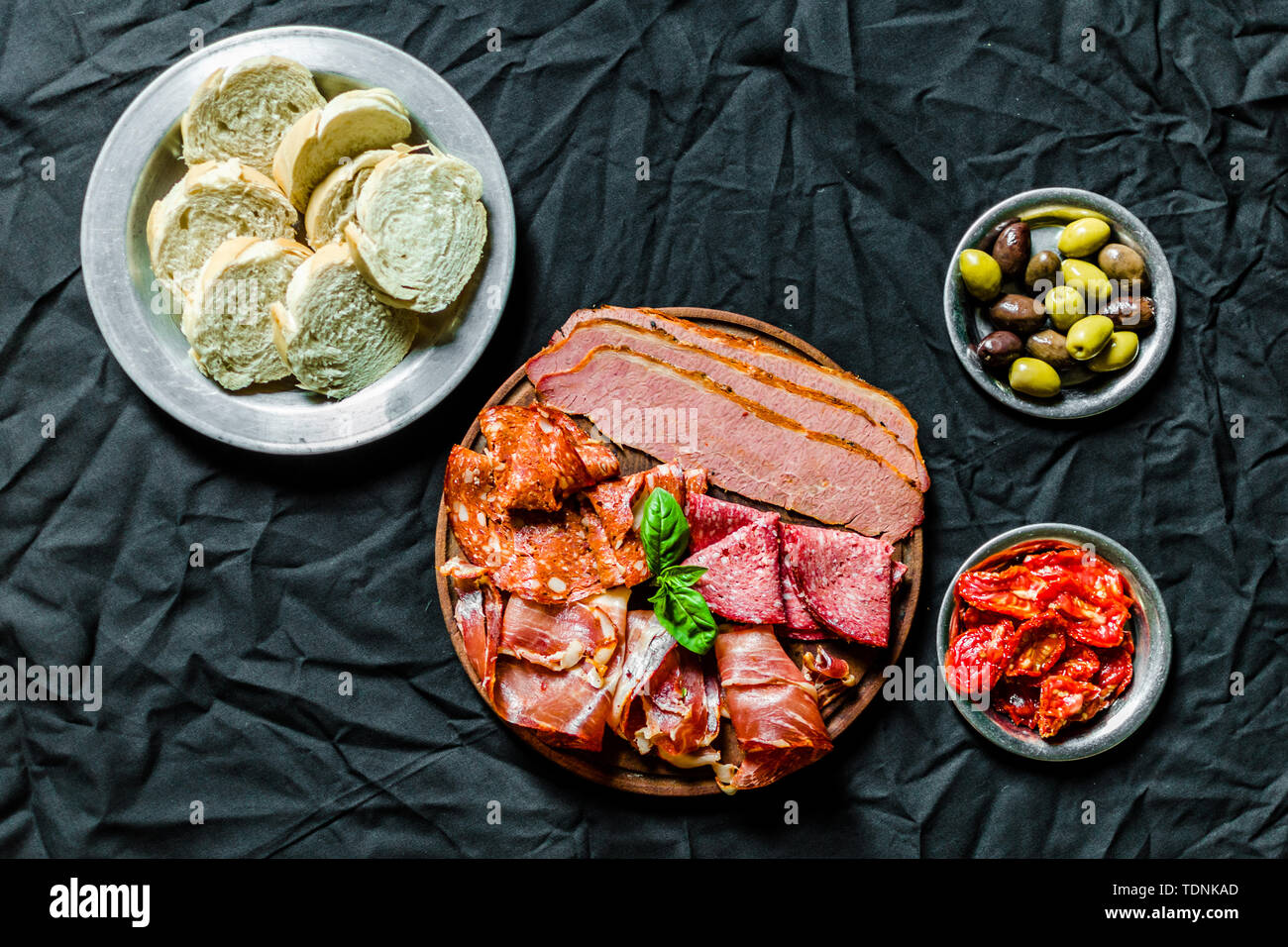 Italian cold meat antipasti delicatessen platter against black ...
