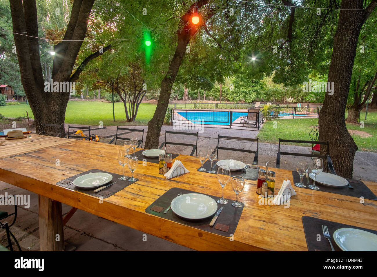 Wooden table with fancy dishes and wine glasses outside Stock Photo - Alamy