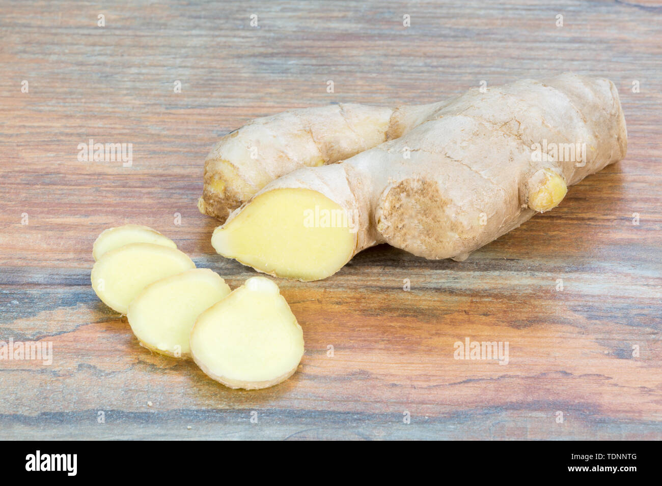 Ginger and cut ginger slices on table Stock Photo - Alamy