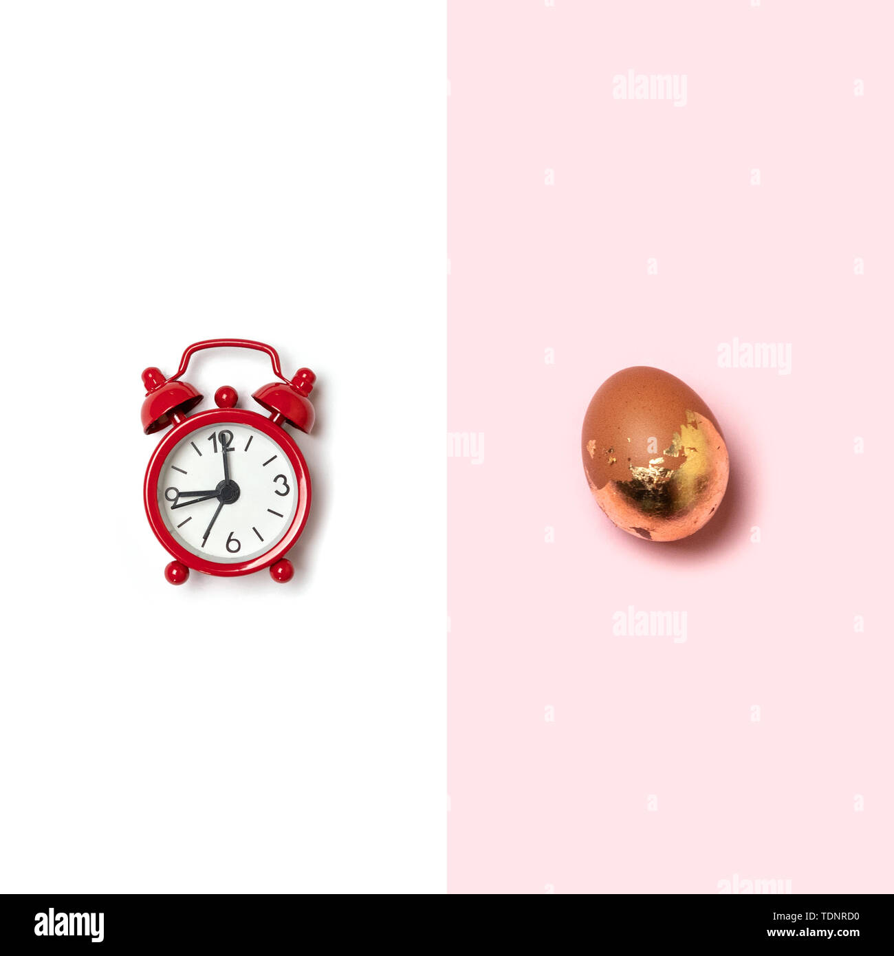Creative layout made of easter gold egg with red alarm clock on white ...