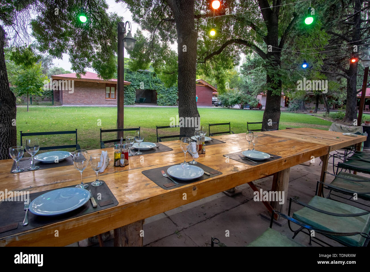 Wooden table with fancy dishes and wine glasses outside Stock Photo - Alamy
