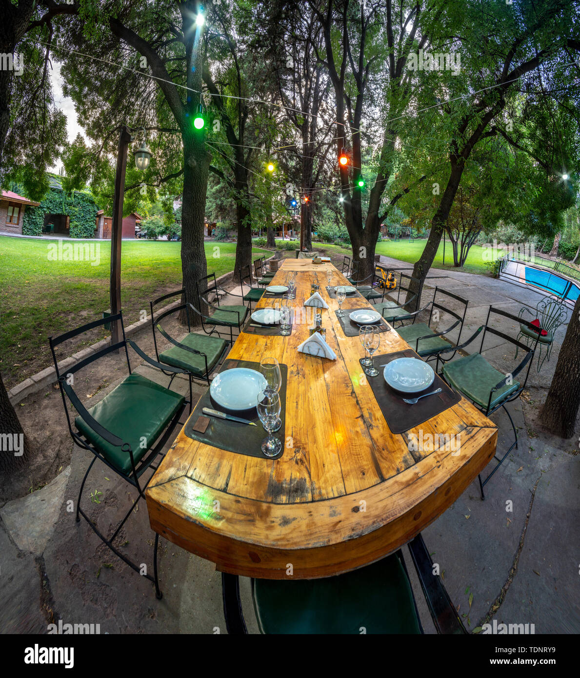 Wooden table with fancy dishes and wine glasses outside Stock Photo - Alamy