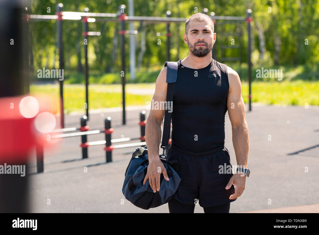 Young muscular athlete in activewear carrying bag while moving down ...