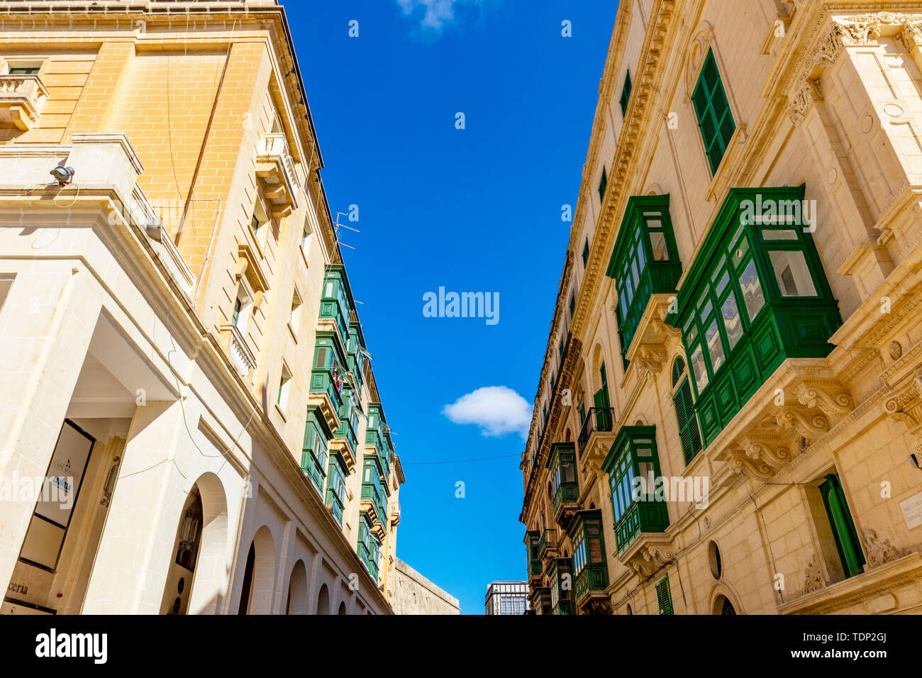 Typical narrow maltese streets with colorful traditional windows and ...