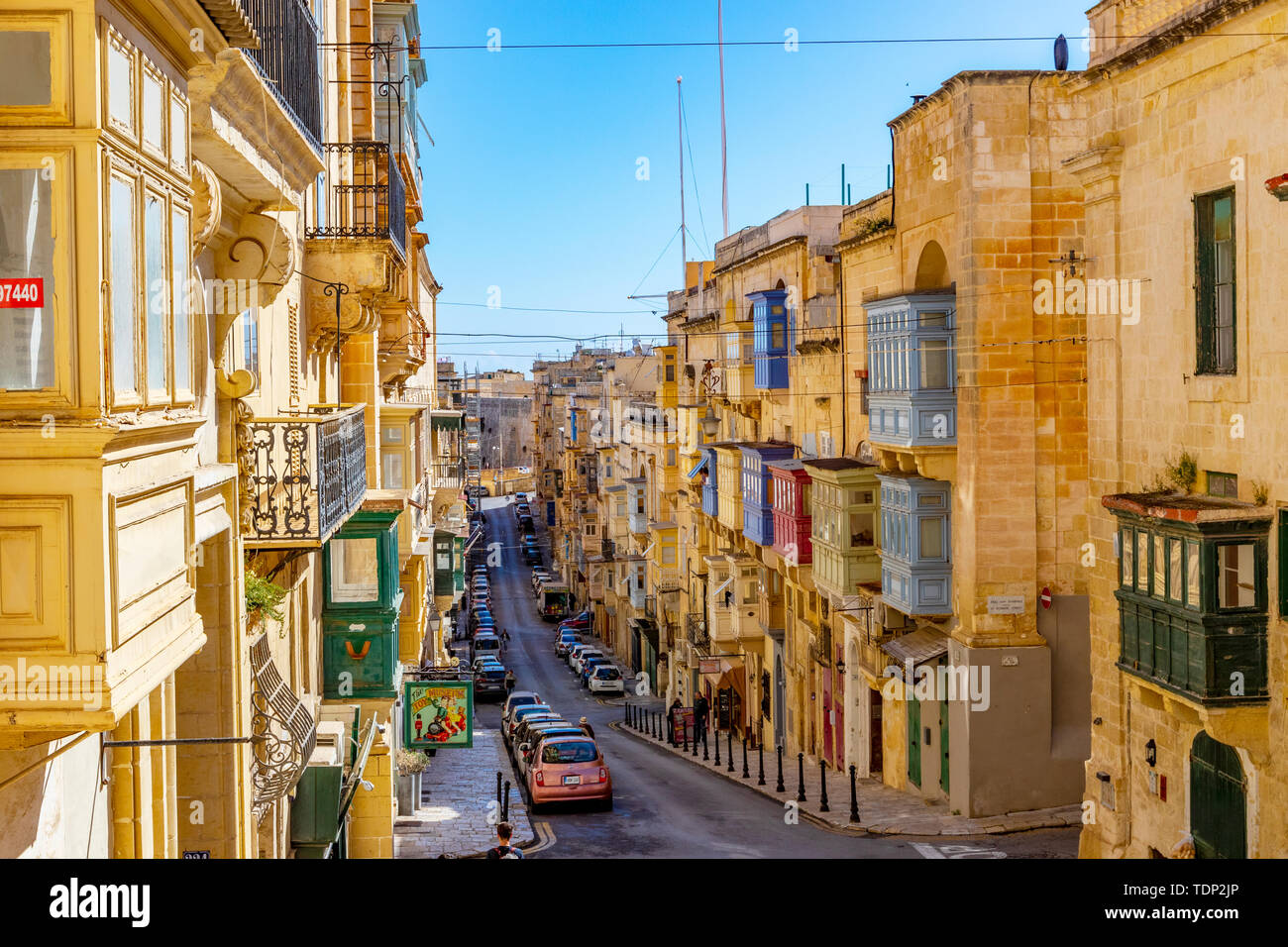 Typical narrow maltese streets with colorful traditional windows and ...