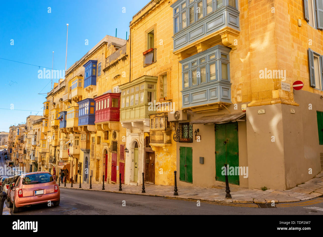 Typical narrow maltese streets with colorful traditional windows and ...