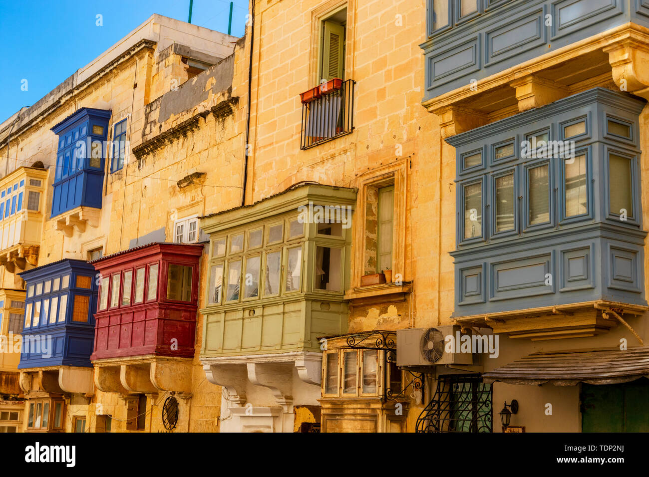 Typical narrow maltese streets with colorful traditional windows and ...