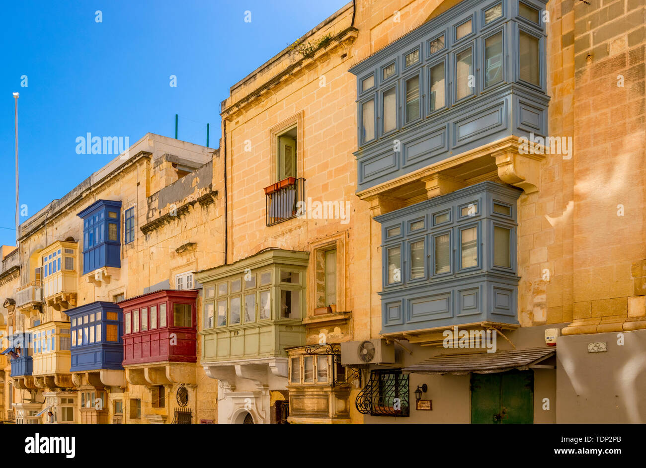 Typical narrow maltese streets with colorful traditional windows and ...
