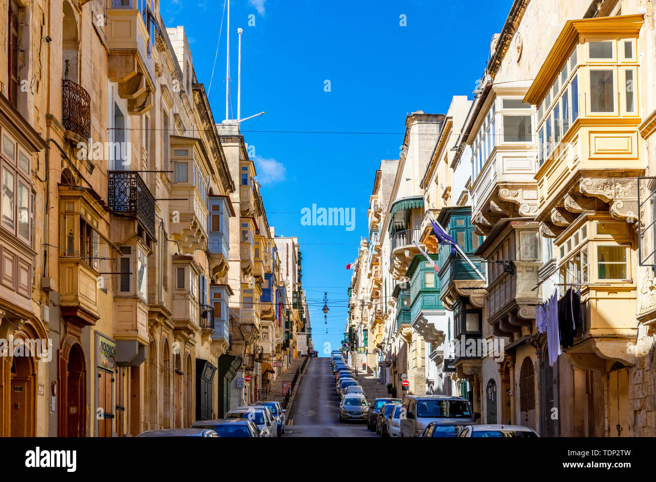 Typical narrow maltese streets with colorful traditional windows and ...