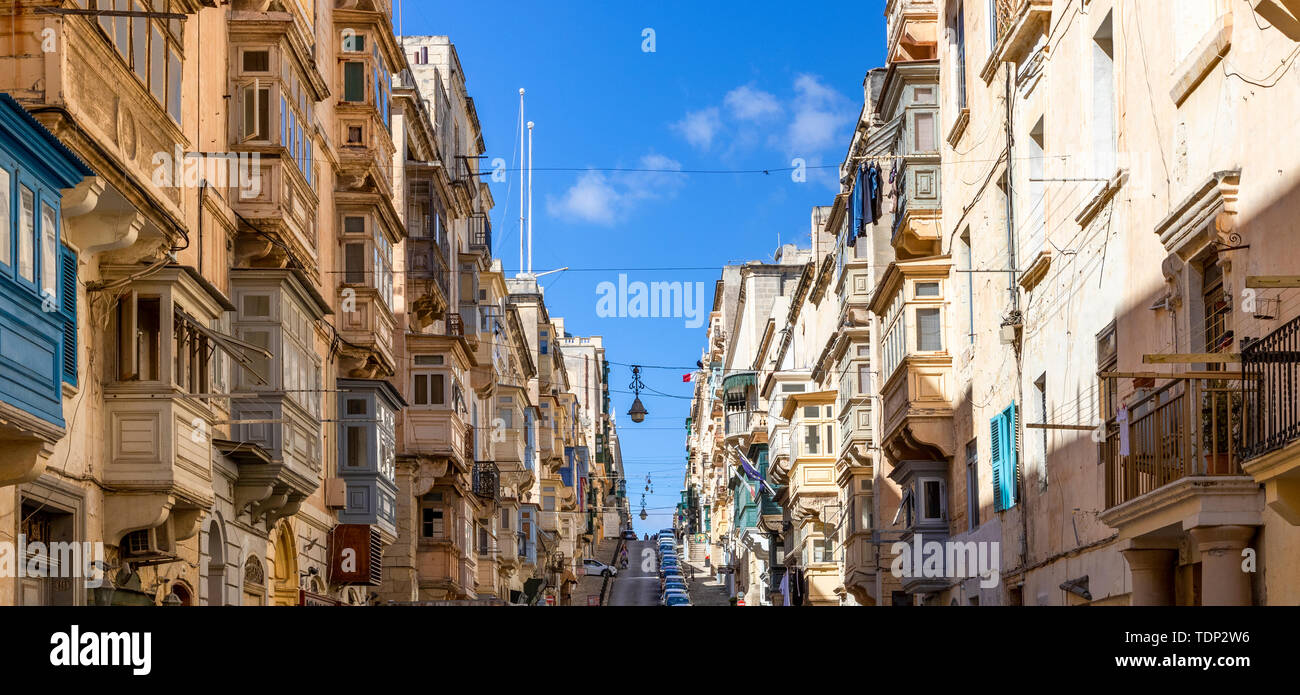 Typical narrow maltese streets with colorful traditional windows and ...